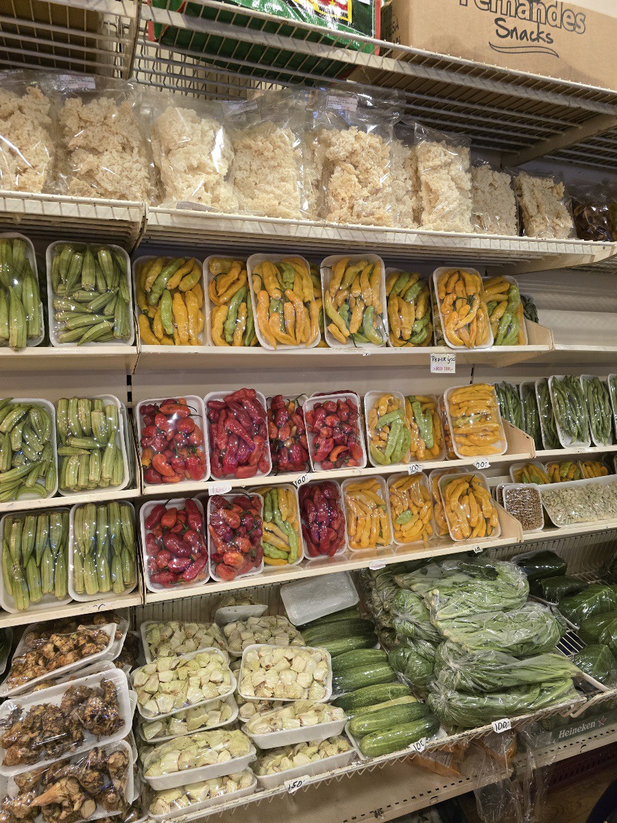 Travelers purchase locally grown Surinamese fruit and vegetables at Paramaribo Airport before ...